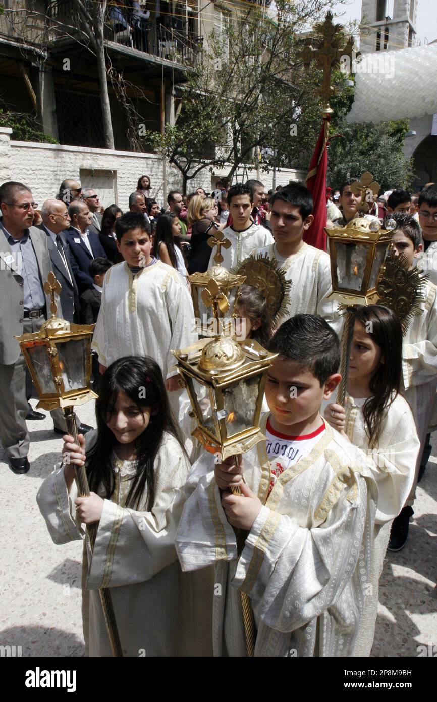 Syrian Catholic devotees hold up lights and candles during the ...