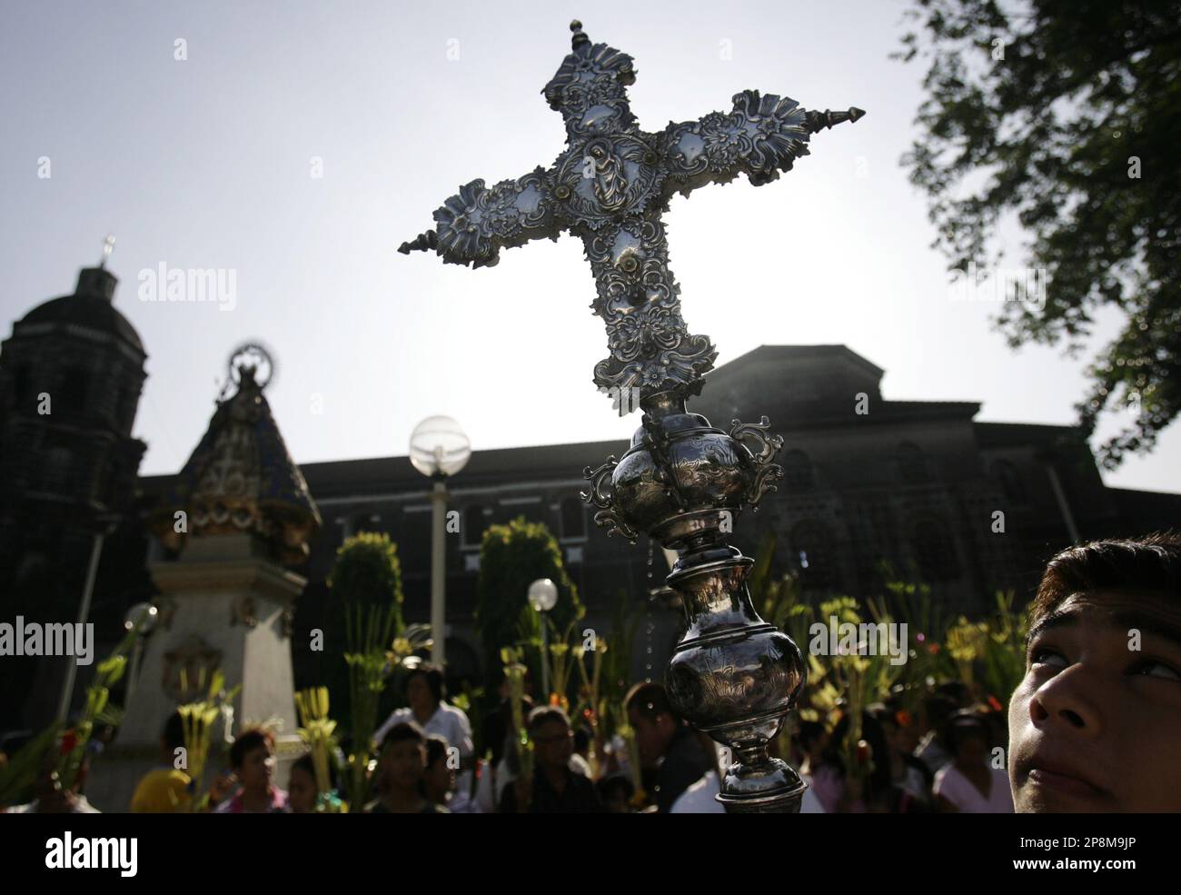 A Filipino altar boy carries a cross during Palm Sunday rites, April 5 ...