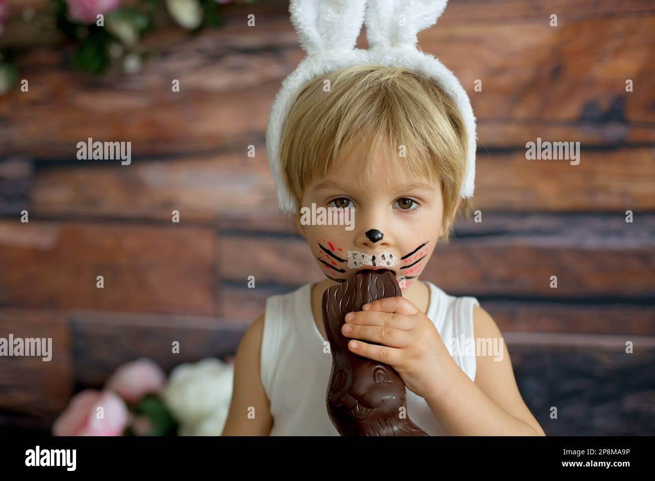 Little toddler boy, child with rabbit painted on the face, eating ...