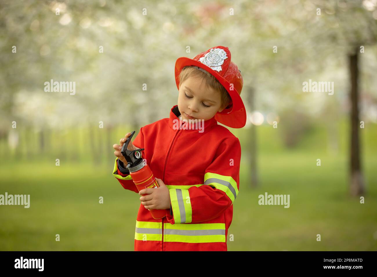 Little toddler child with fireman costume in park, pretending to be ...