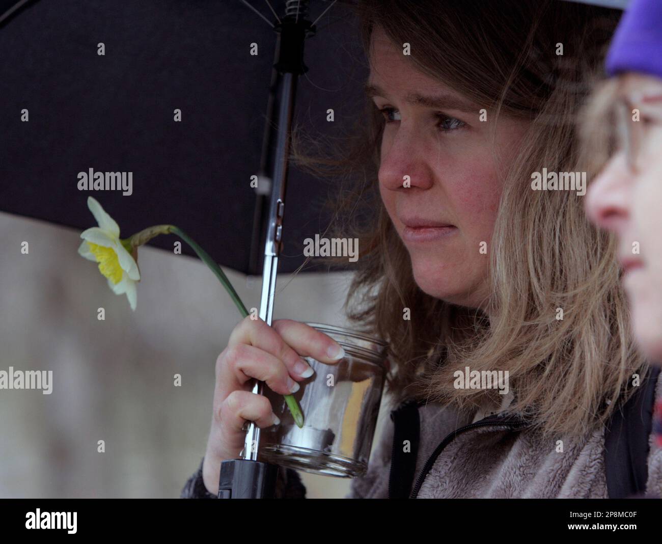 Kris Gilbert of Binghamton, N.Y., holds a daffodil during a peace vigil ...