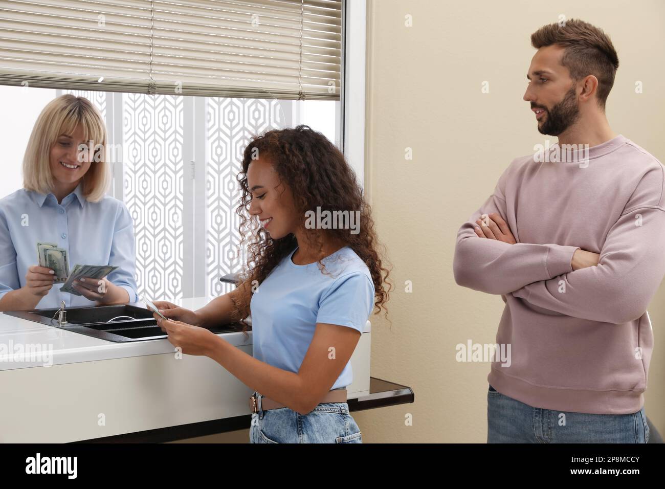 African American woman with money at cash department window in bank ...