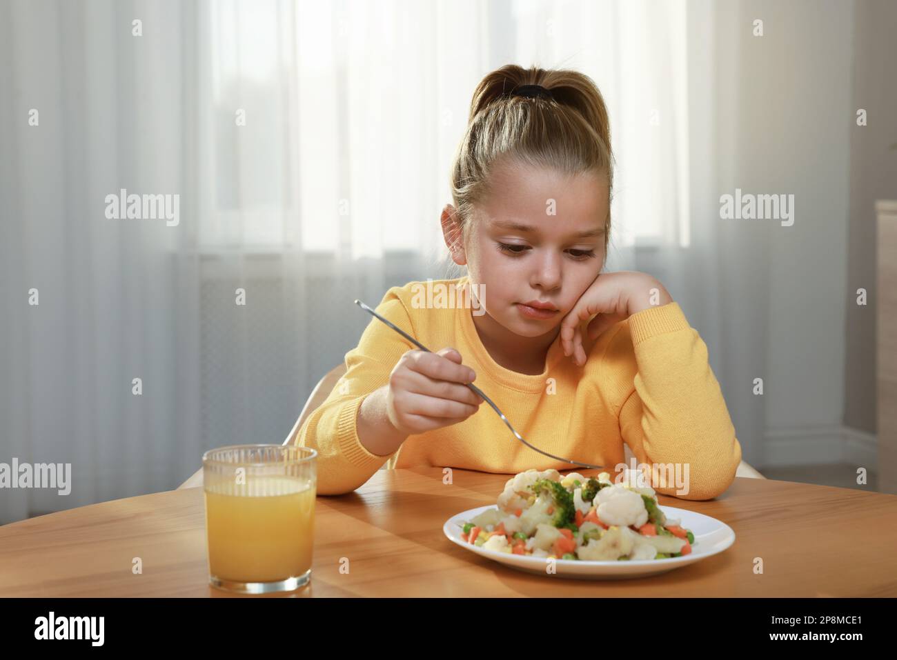 Cute little girl refusing to eat vegetable salad at home Stock Photo ...