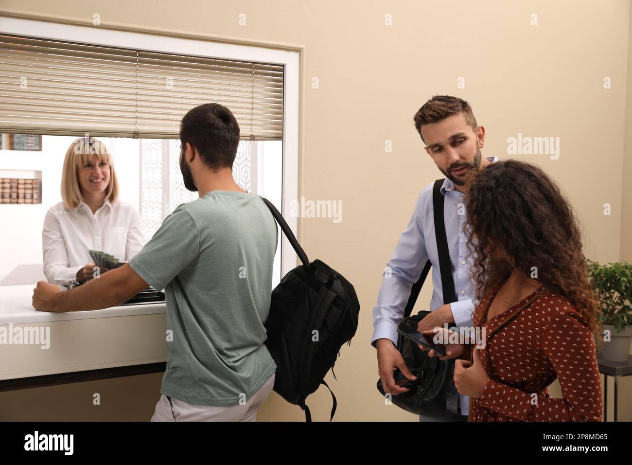 Man waiting for money and other people in line at cash department ...