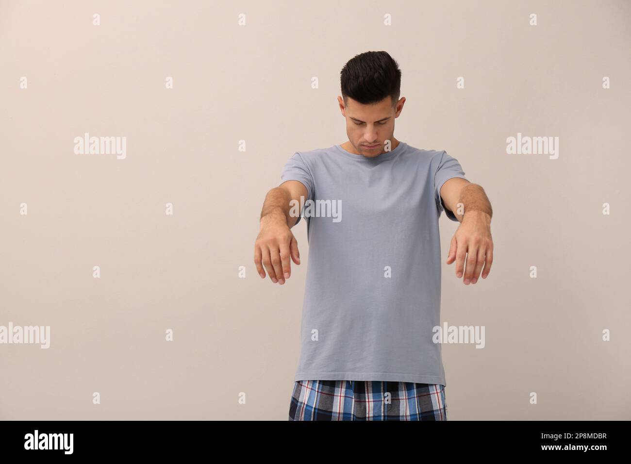 Somnambulist wearing pajamas on beige background. Sleepwalking Stock ...