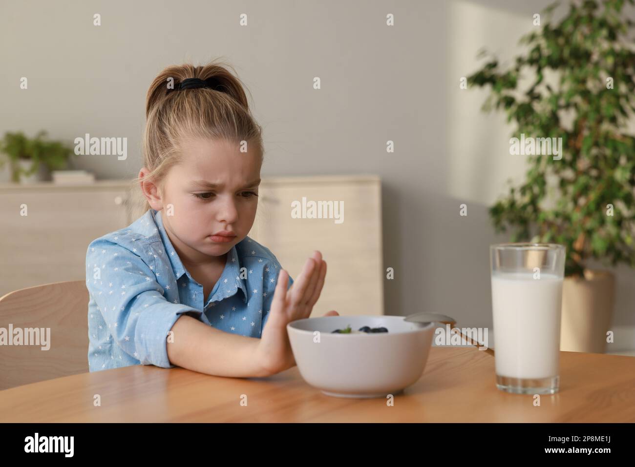 Cute little girl refusing to eat her breakfast at home Stock Photo - Alamy