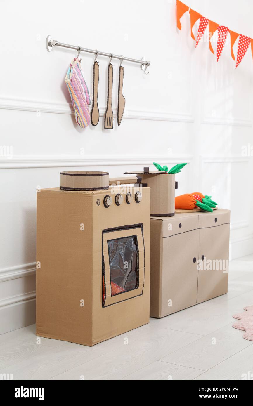 Toy cardboard kitchen with stove and utensils indoors Stock Photo - Alamy