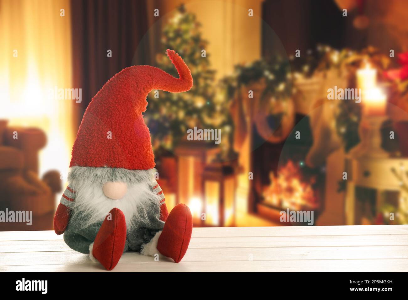Funny Christmas gnome on white wooden table in room with festive ...