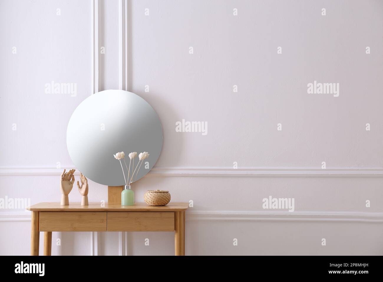 Air reed freshener and decor on console table near white wall with ...