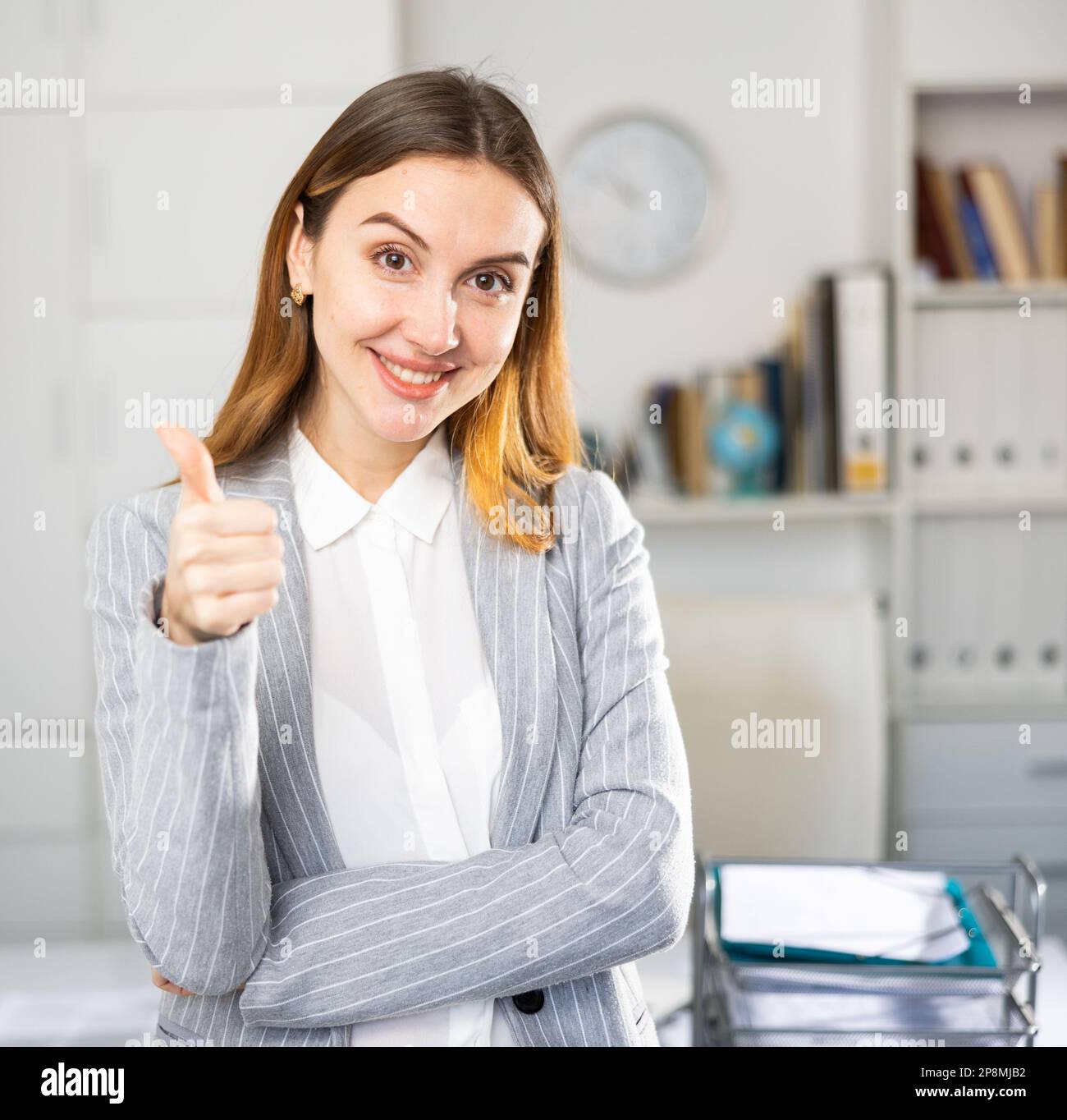 Portrait of successful business woman holding thumb up Stock Photo - Alamy