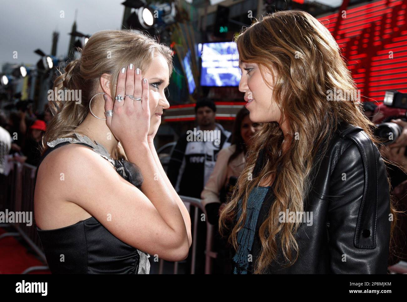Miley Cyrus, right, and Emily Osment speak to each other at the ...