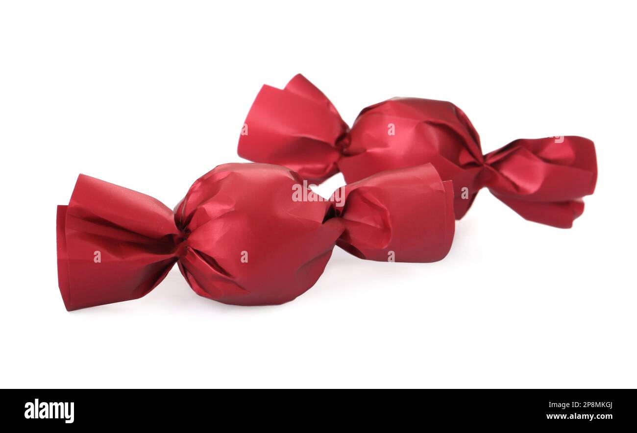 Delicious candies in red wrappers isolated on white Stock Photo - Alamy