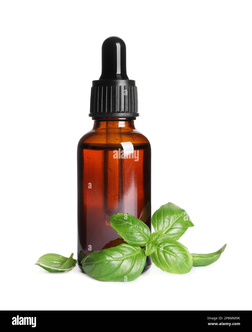 Glass bottle of basil essential oil and leaves on white background ...