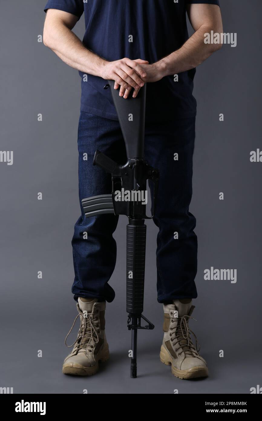 Assault gun. Man holding rifle on dark background, closeup Stock Photo ...