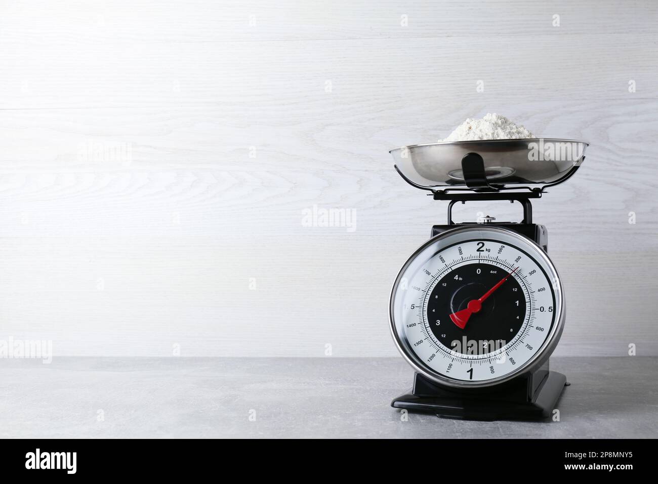 Kitchen scale with flour on grey table. Space for text Stock Photo - Alamy