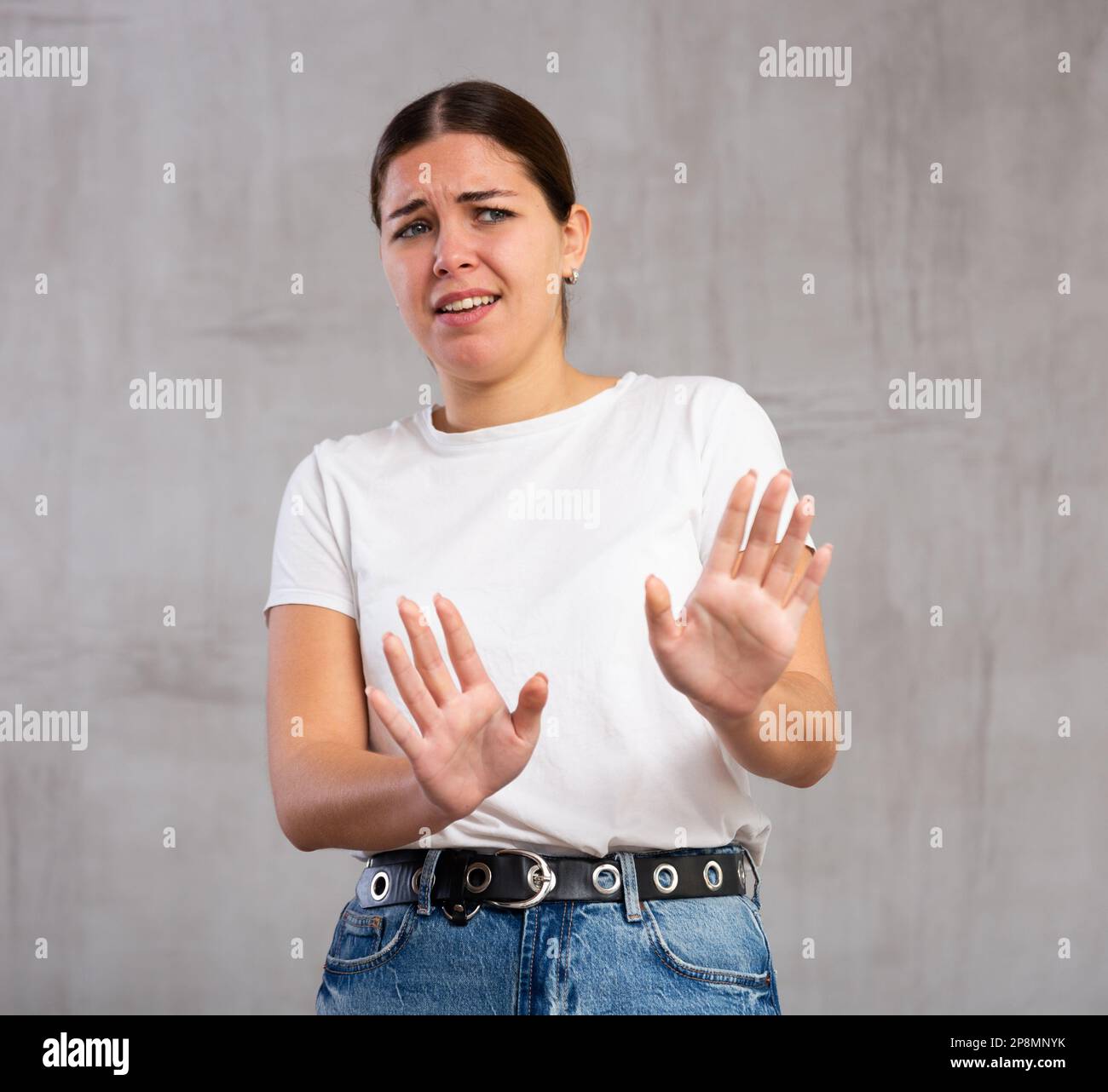 Irritated young woman posing crossly against gray background Stock ...