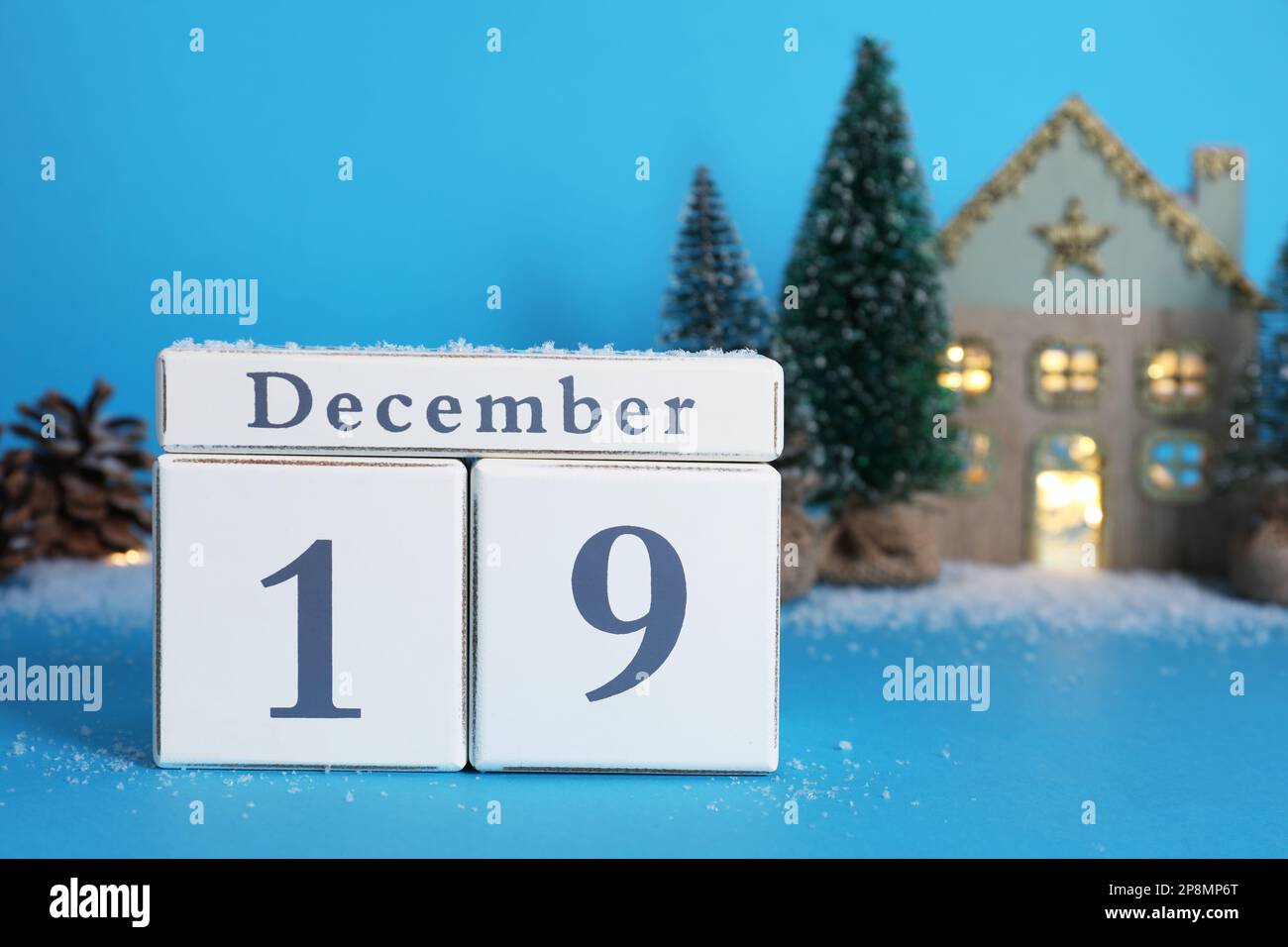 Wooden block calendar with date 19th of December and festive decor on ...