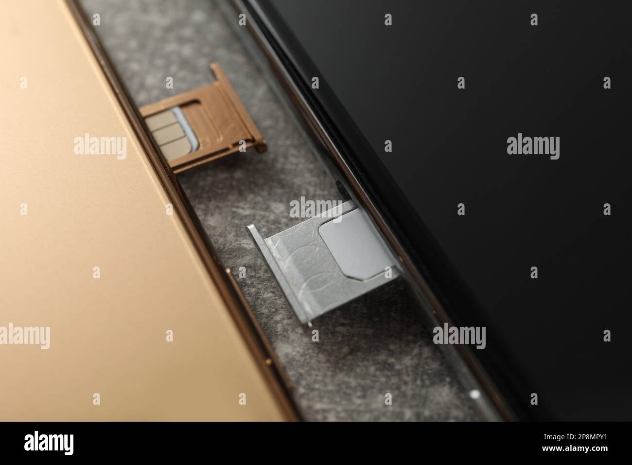 Mobile phones with Sim cards in trays on grey table, closeup Stock ...