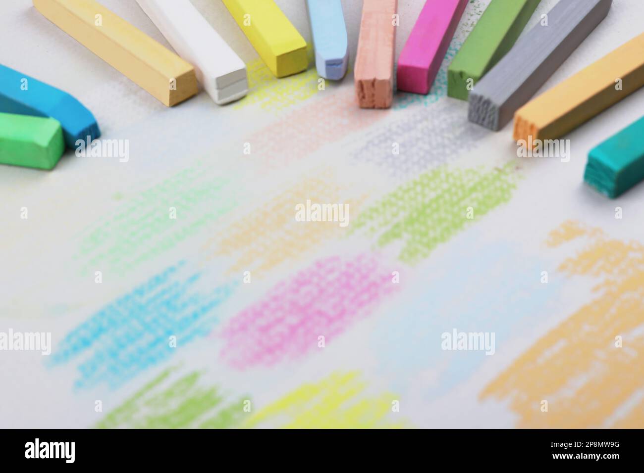 Colorful pastel chalks and scribbles on white background, closeup ...
