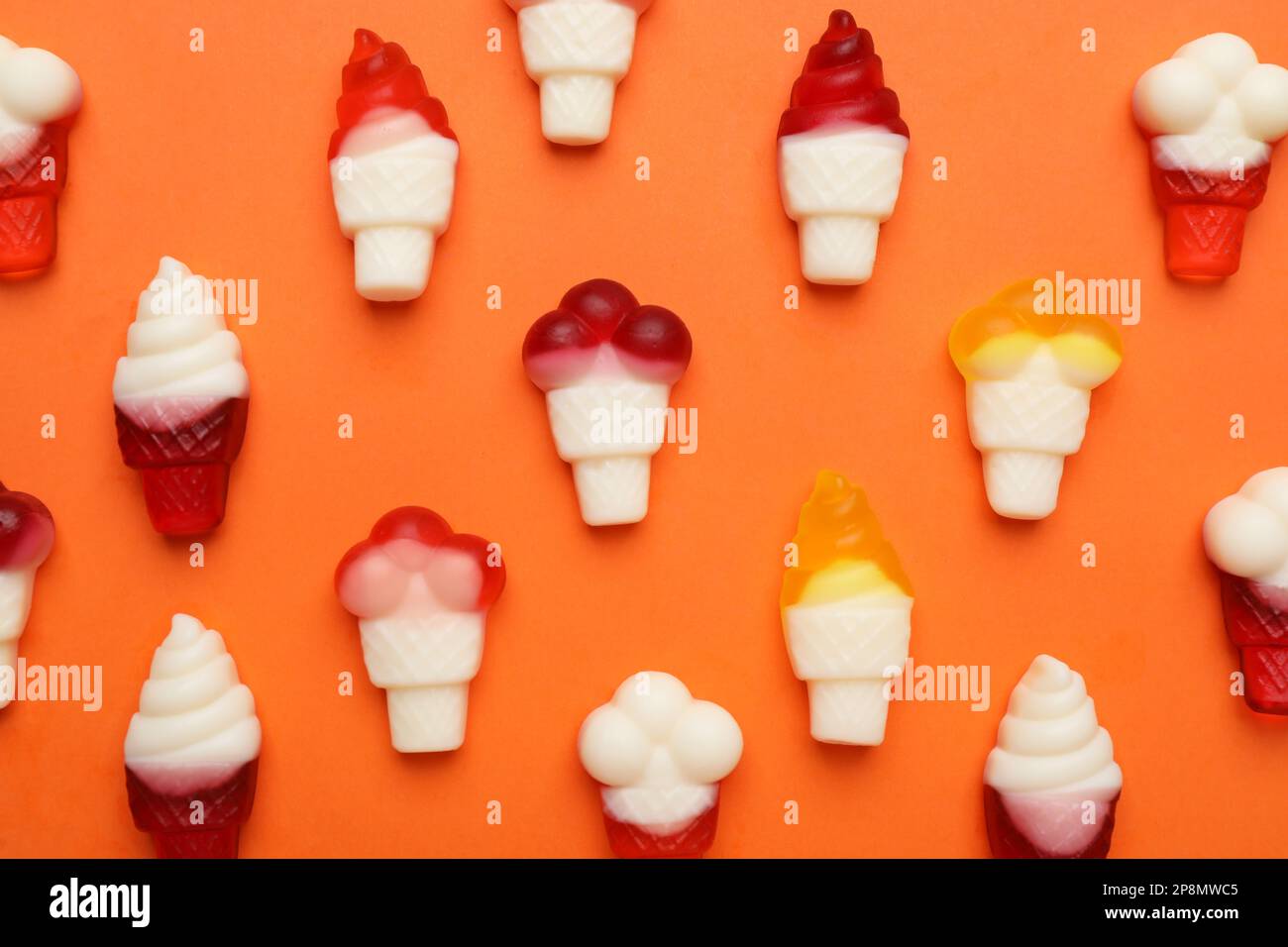 Delicious gummy ice cream cones candies on orange background, flat lay ...