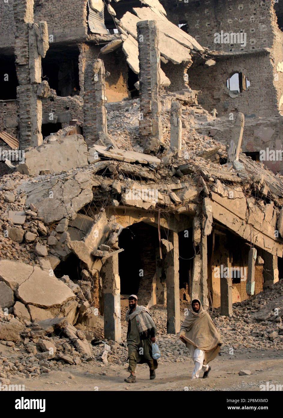 ** FILE ** The Oct. 8, 2003 photo shows Afghan men walking past a ...