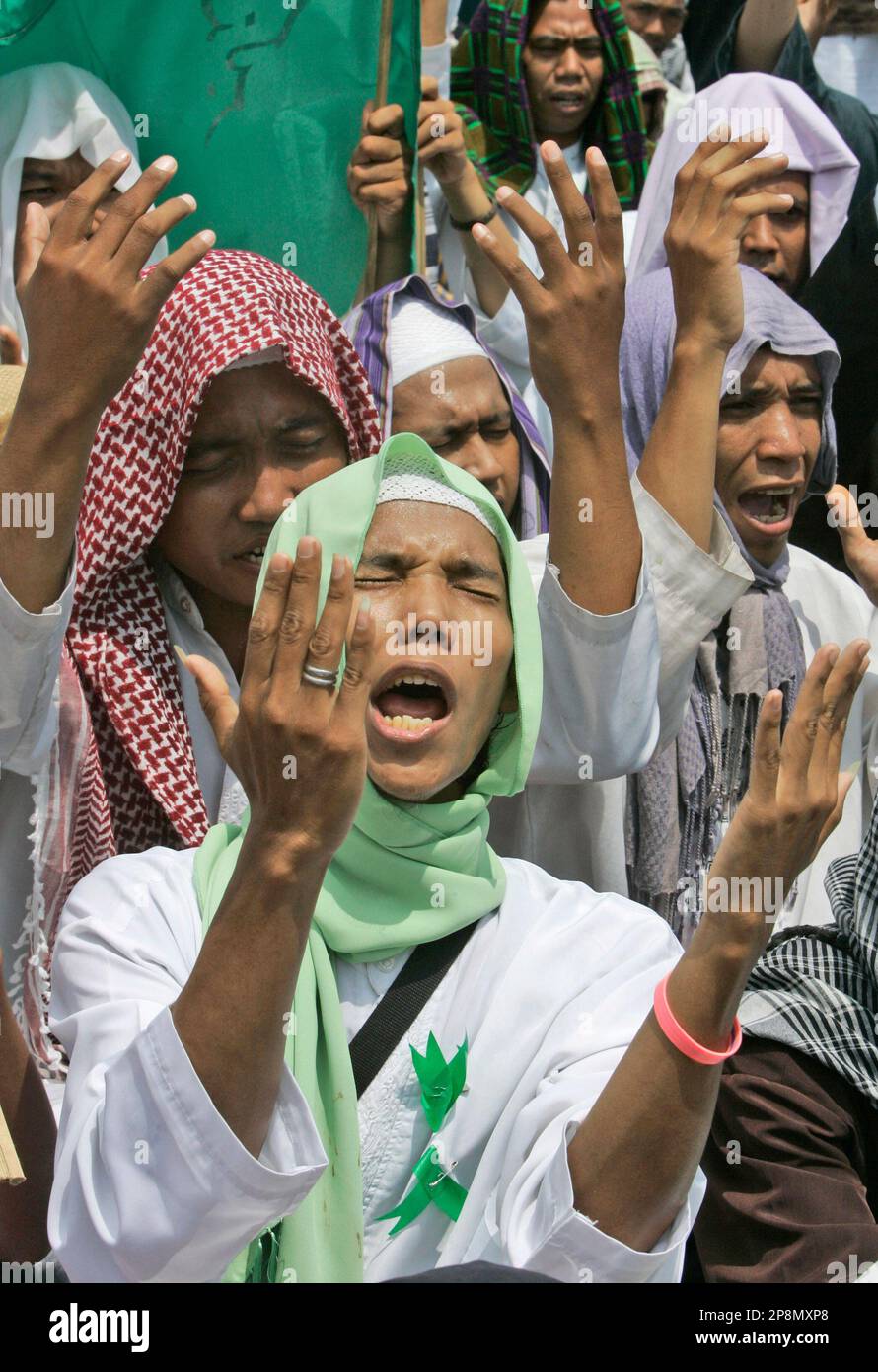 Members of Indonesian hard line Islamic groups pray during a rally ...