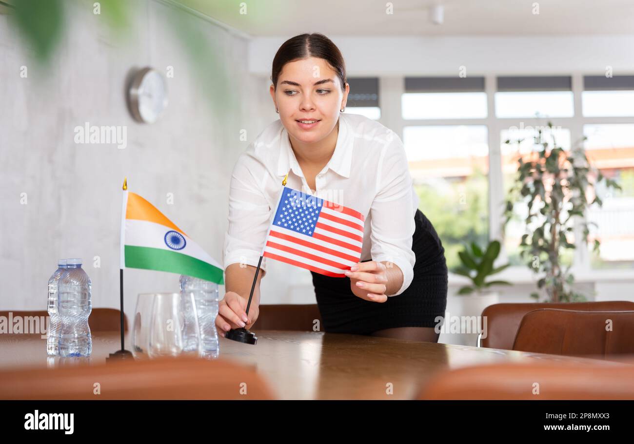 Female secretary places flags of the USA and India on the table before ...