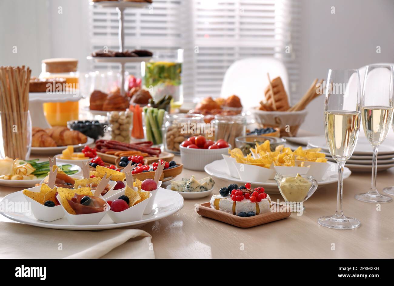 Variety of snacks on wooden table in buffet style indoors Stock Photo ...