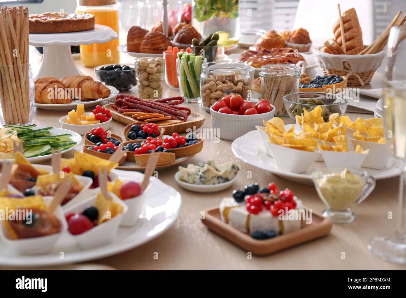 Variety of snacks on wooden table in buffet style indoors Stock Photo ...