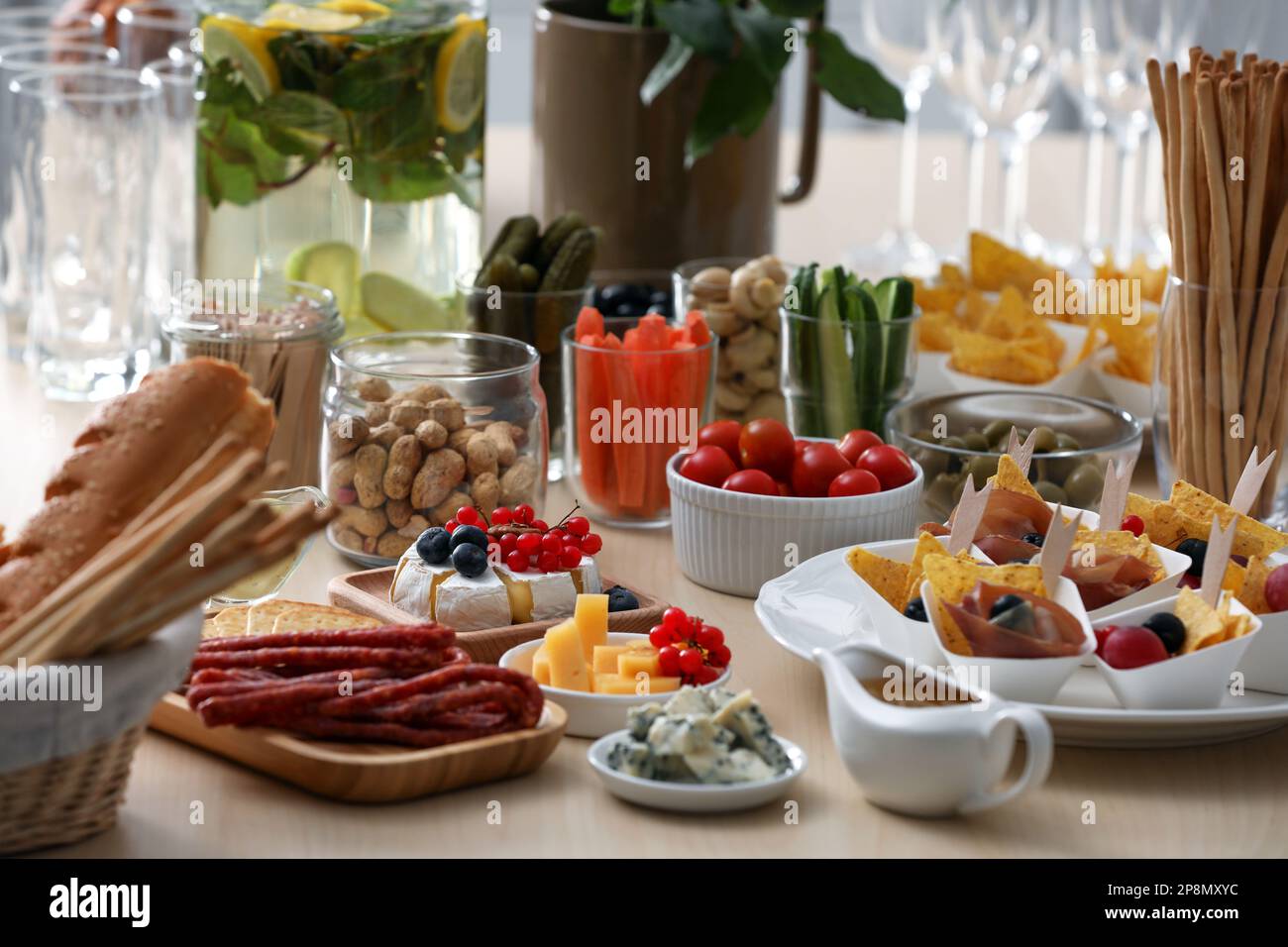 Variety of snacks on wooden table in buffet style indoors Stock Photo ...