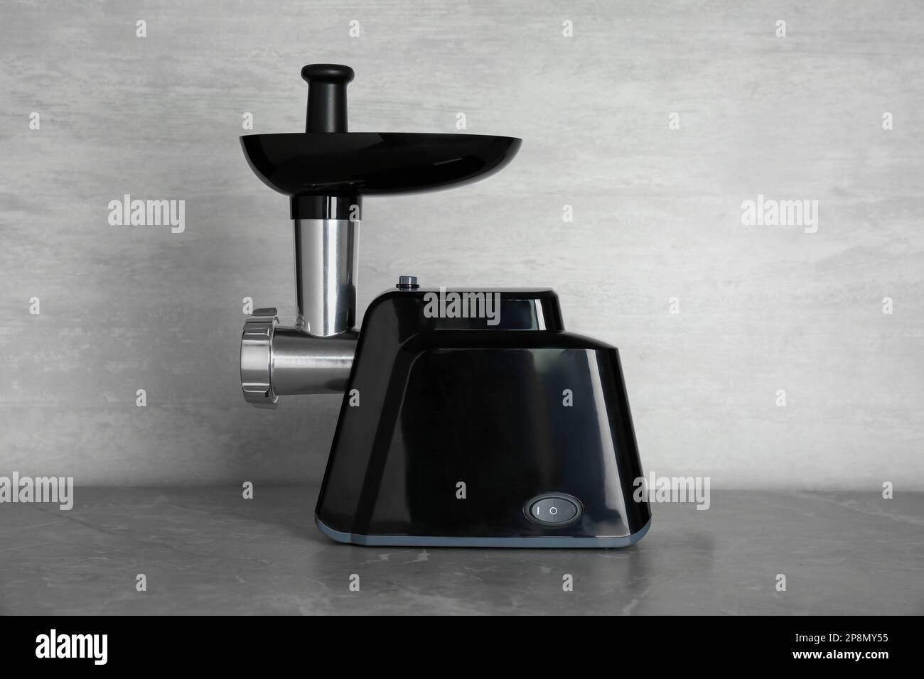 Modern electric meat grinder on grey table Stock Photo - Alamy