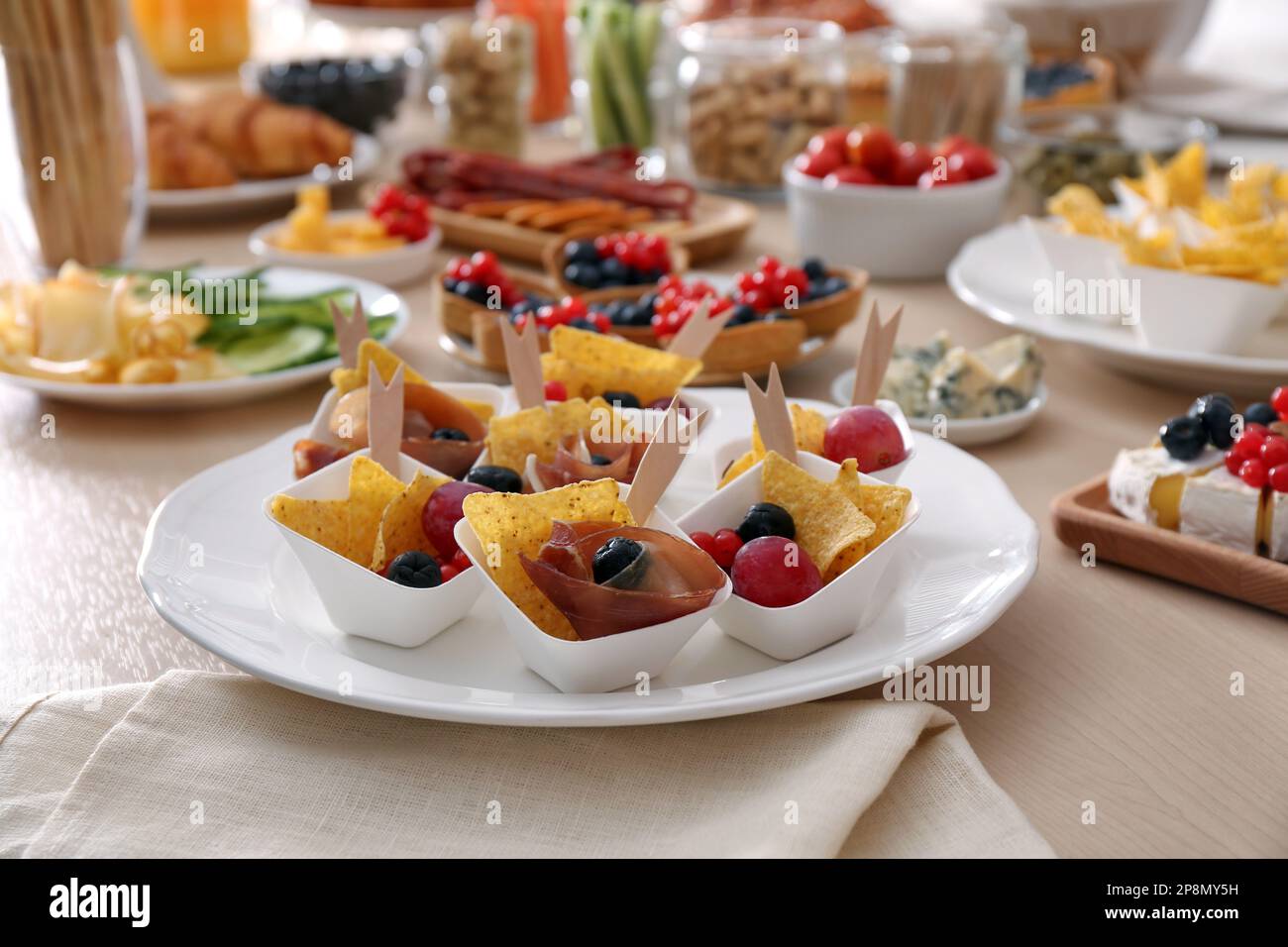 Variety of snacks on wooden table in buffet style Stock Photo - Alamy