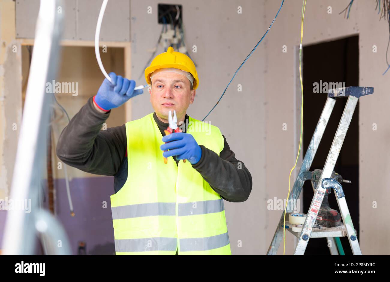 Worker repairing wires while installing electricity Stock Photo - Alamy