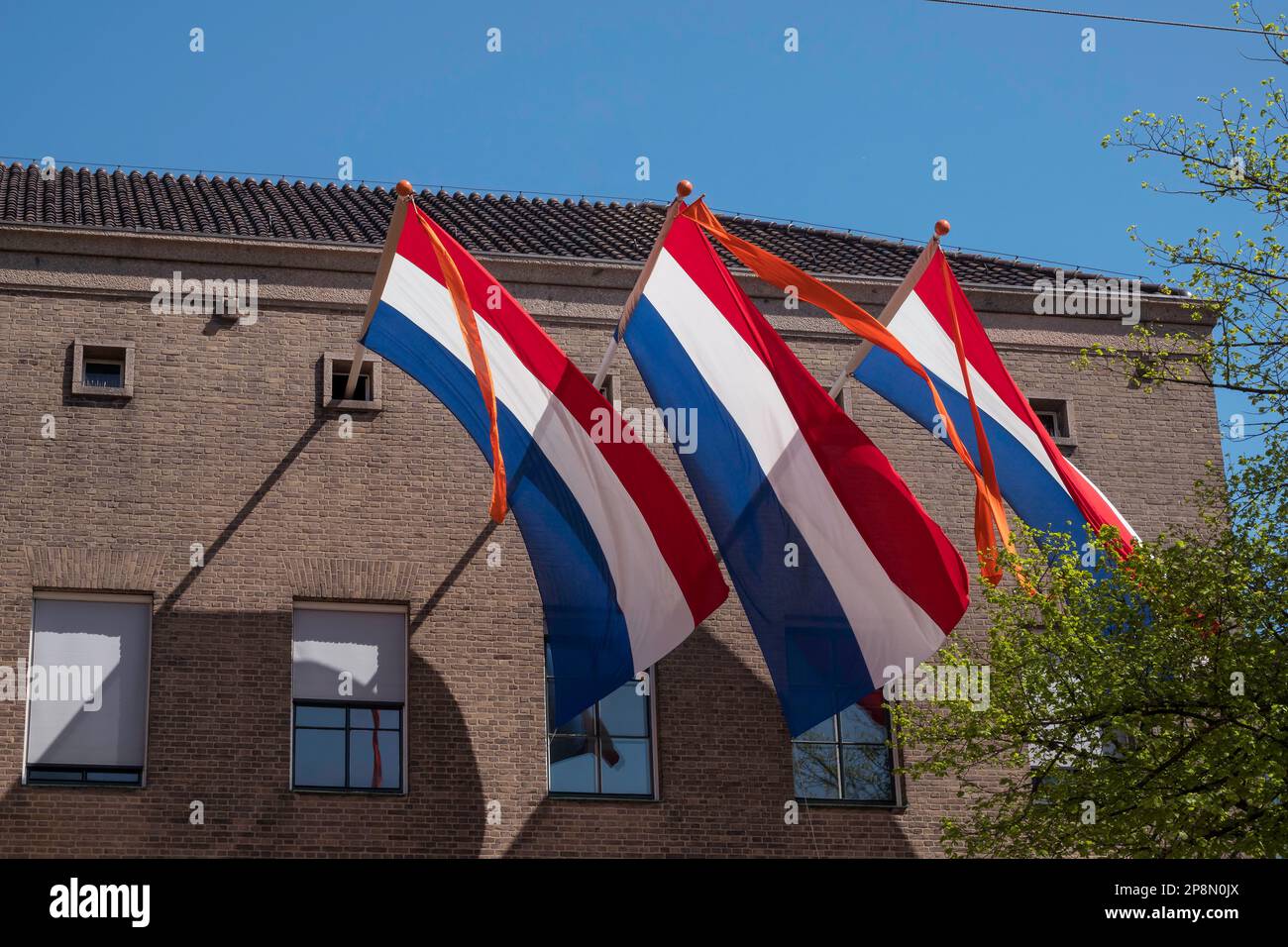 three times a Dutch flag in red white blue with an orange ribbon Stock ...