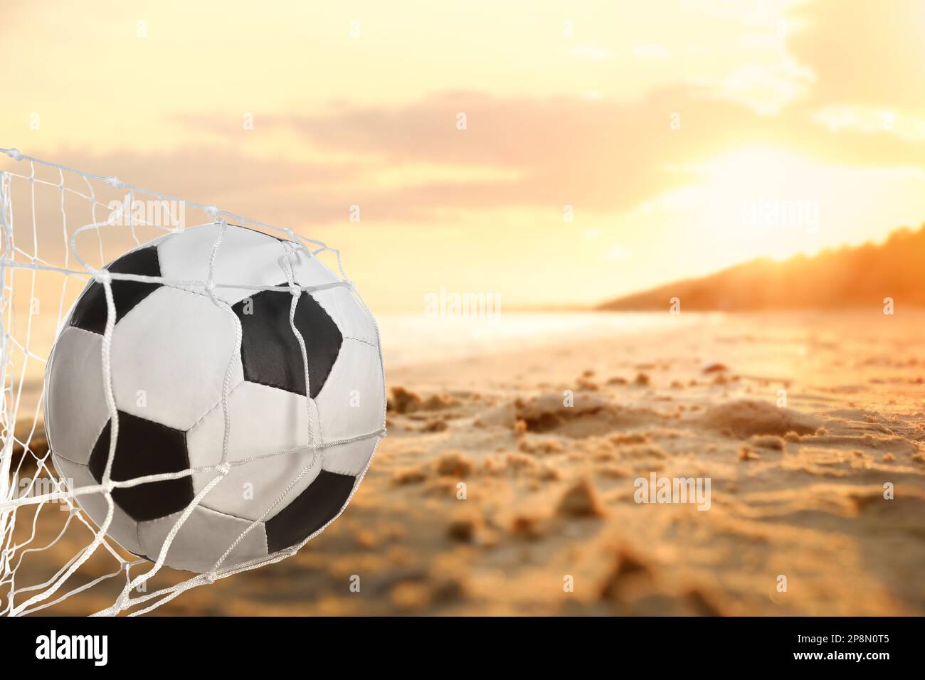 Soccer ball in net on sandy coast near sea. Beach football Stock Photo ...