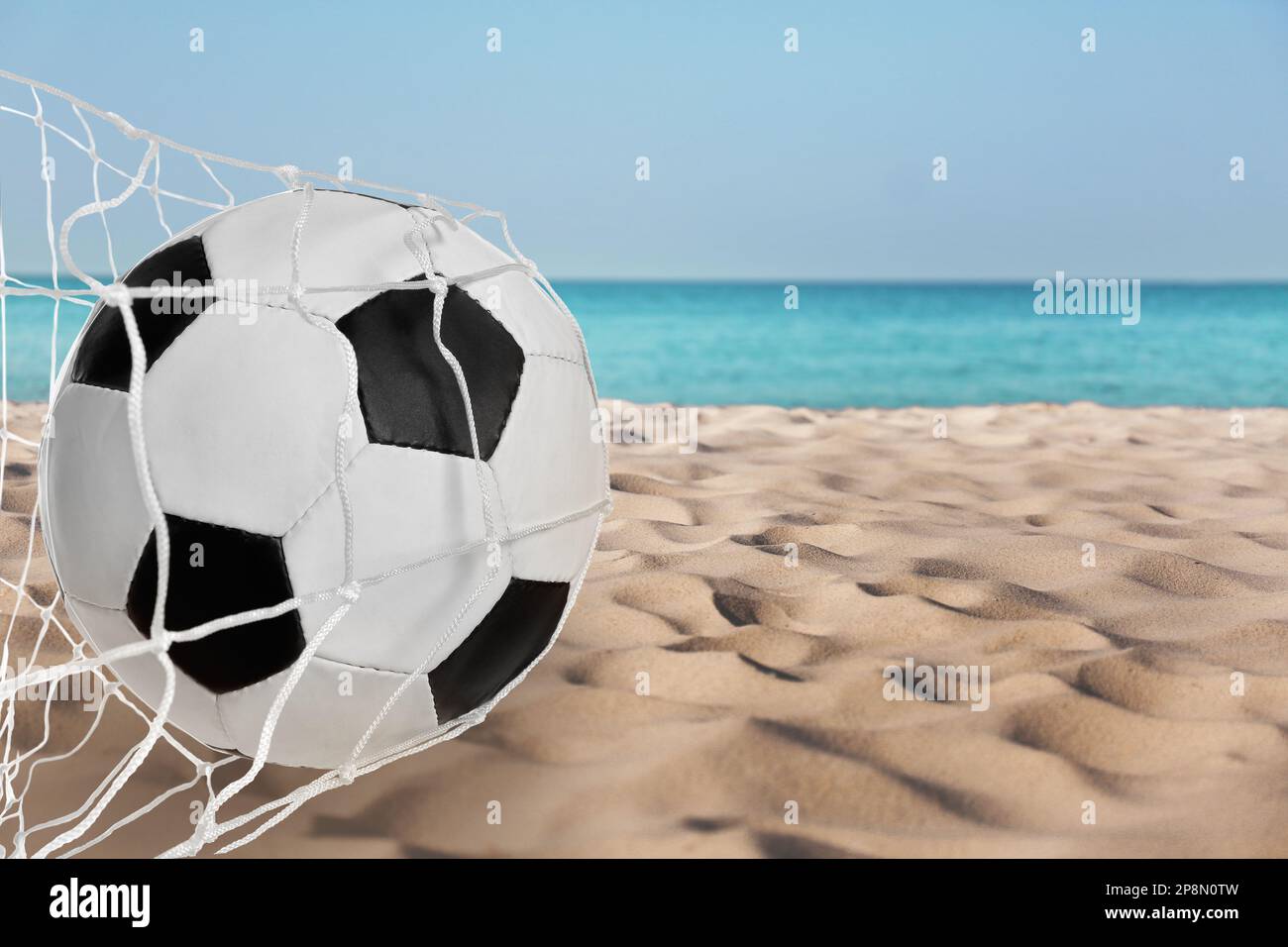 Soccer ball in net on sandy coast near sea. Beach football Stock Photo ...