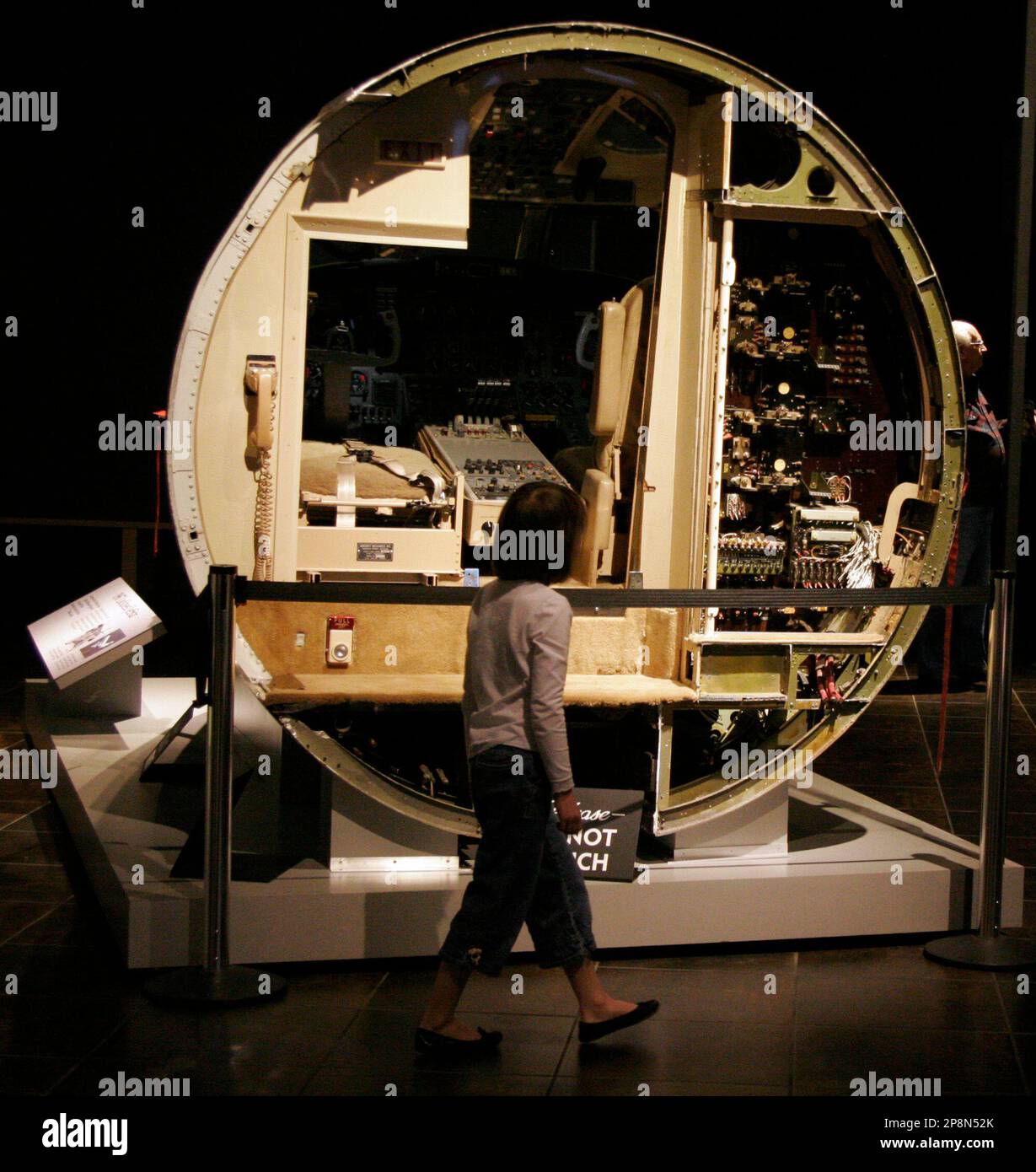 A visitor walks past the cockpit of a jet airplane on display at the ...