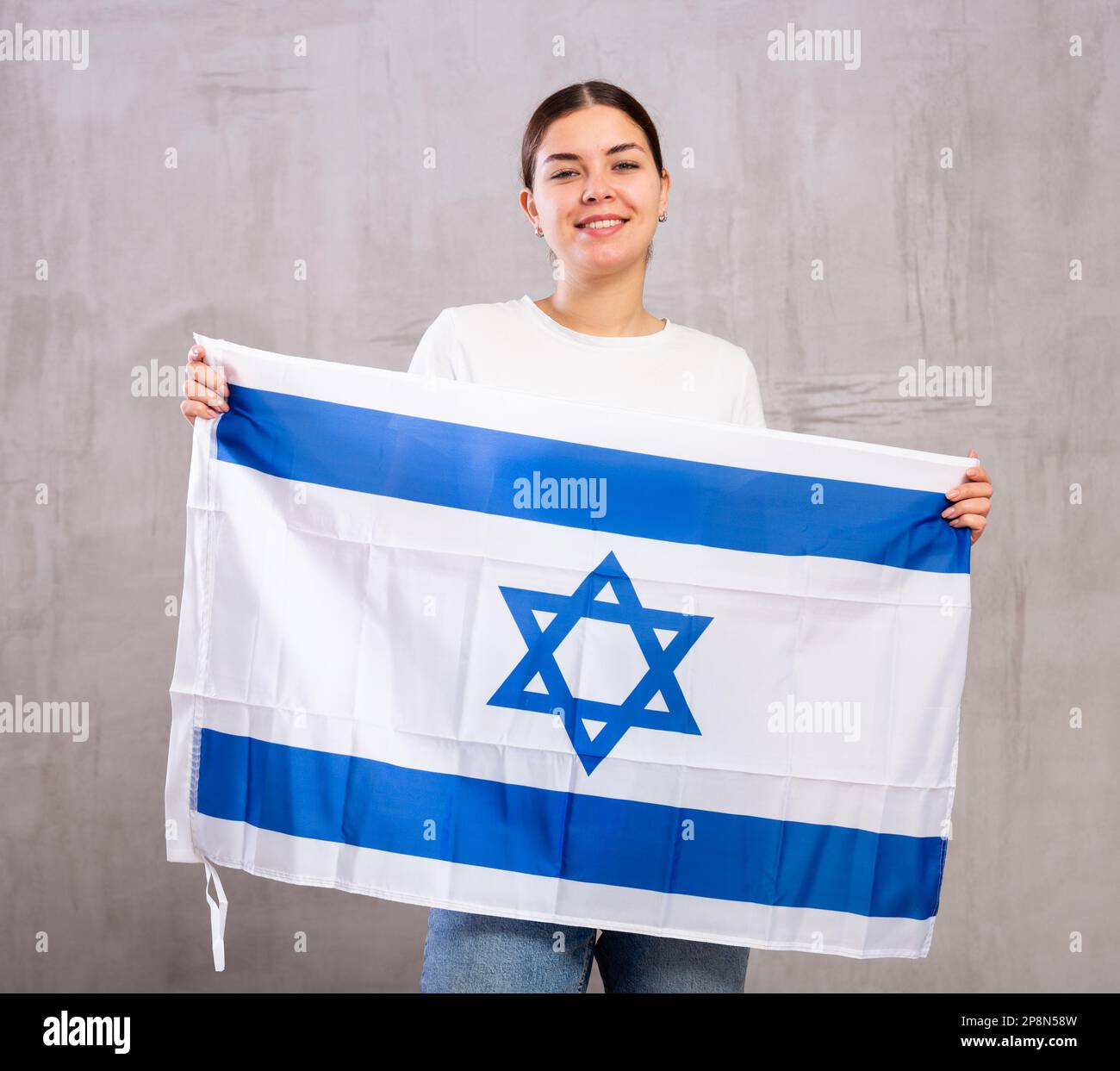 Smiling young woman holding Israel flag Stock Photo - Alamy