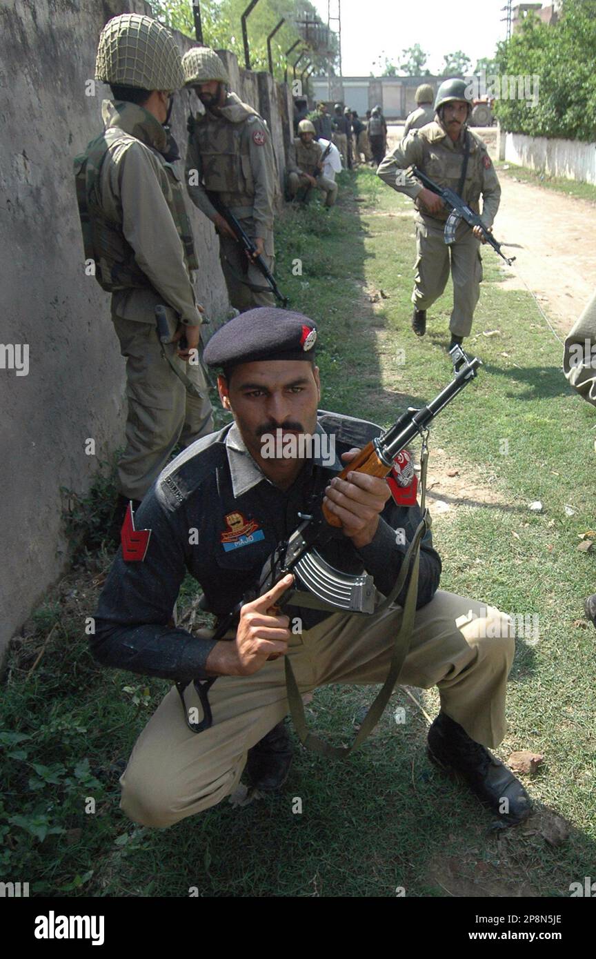 Pakistani security forces take positions outside a police training ...
