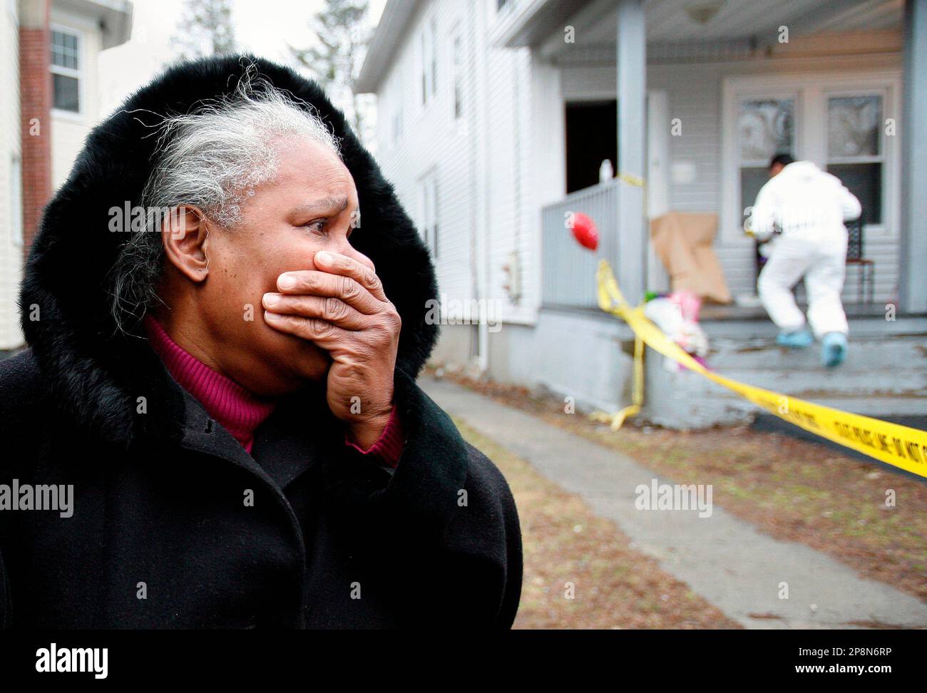 A police investigator enters the house as Mavis Phillips reacts outside ...