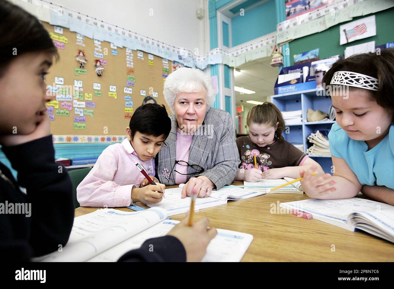 Foster grandparent, Diane Wells, facing center, works with students ...