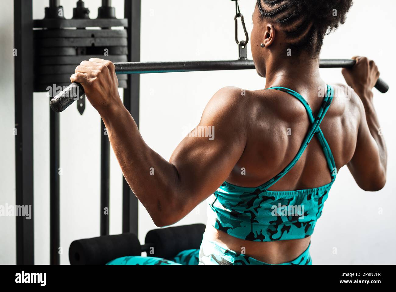 Portrait of muscular woman doing pull-up exercises for back muscles ...