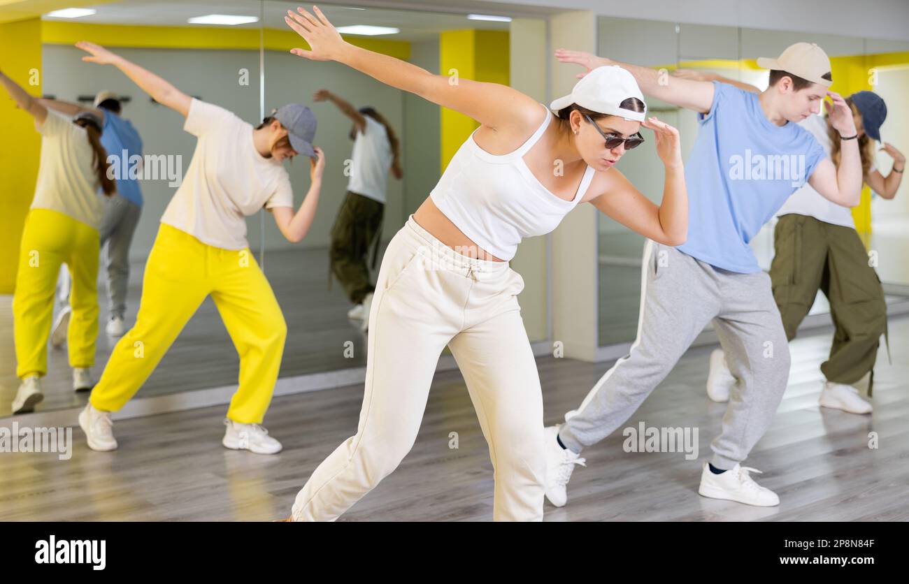 Fit energetic teenagers practicing dance movements and having fun while ...