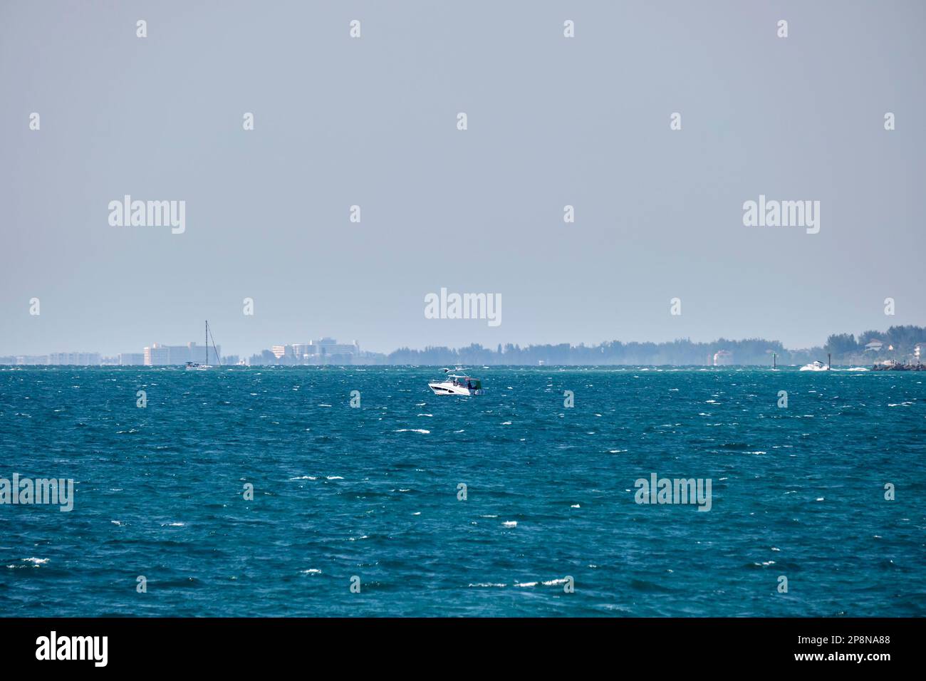 Sea panorama. Small motor boat floats in deap blue bay water under ...