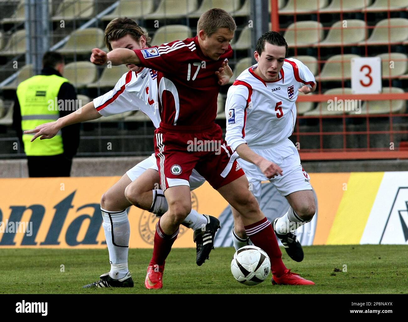 Luxembourg's Jacques Plein, left, and teammate Ben Payal, right, challenge Aleksandrs Cauna of ...