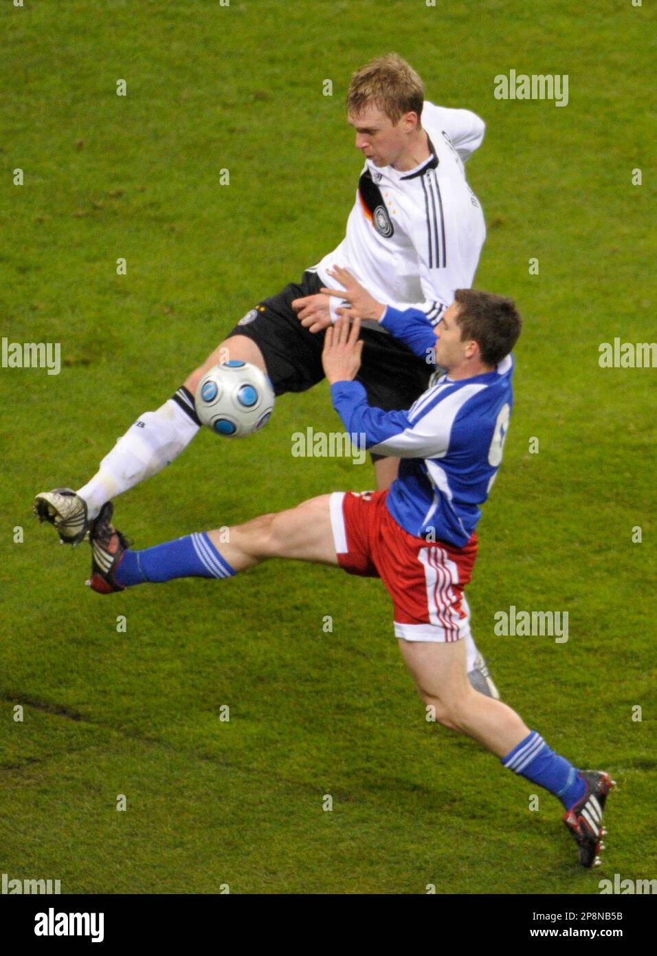 Germany's defender Per Mertesacker, left, is challenged by ...