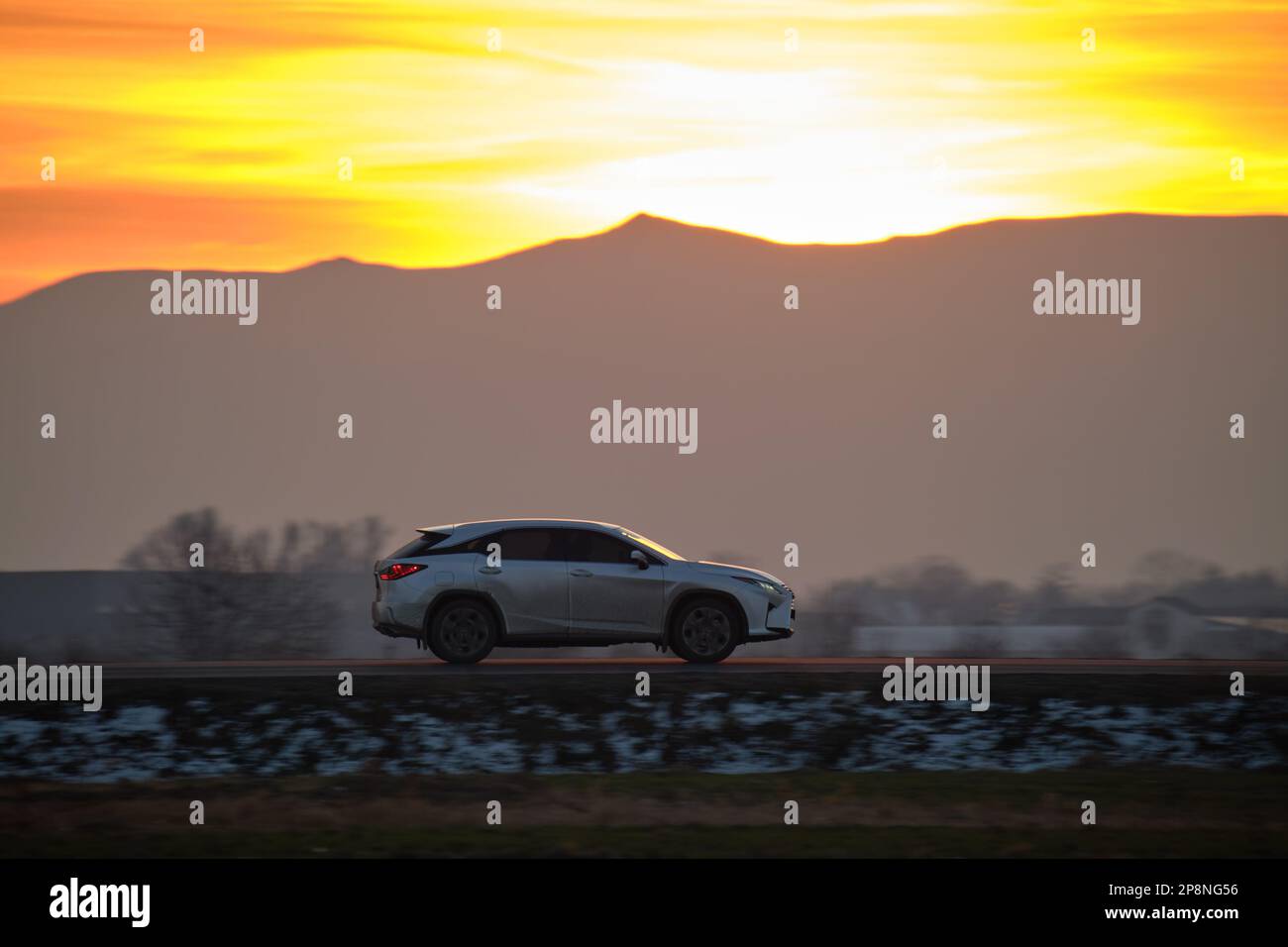 SUV car driving fast on intercity road at sunset. Highway traffic in ...