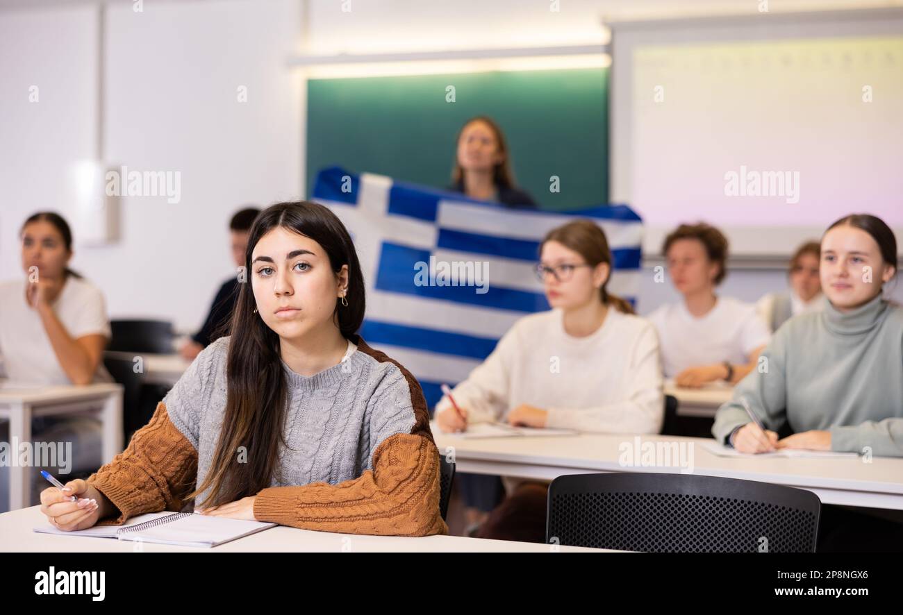 Teacher stands behind students with flag of Greece Stock Photo - Alamy