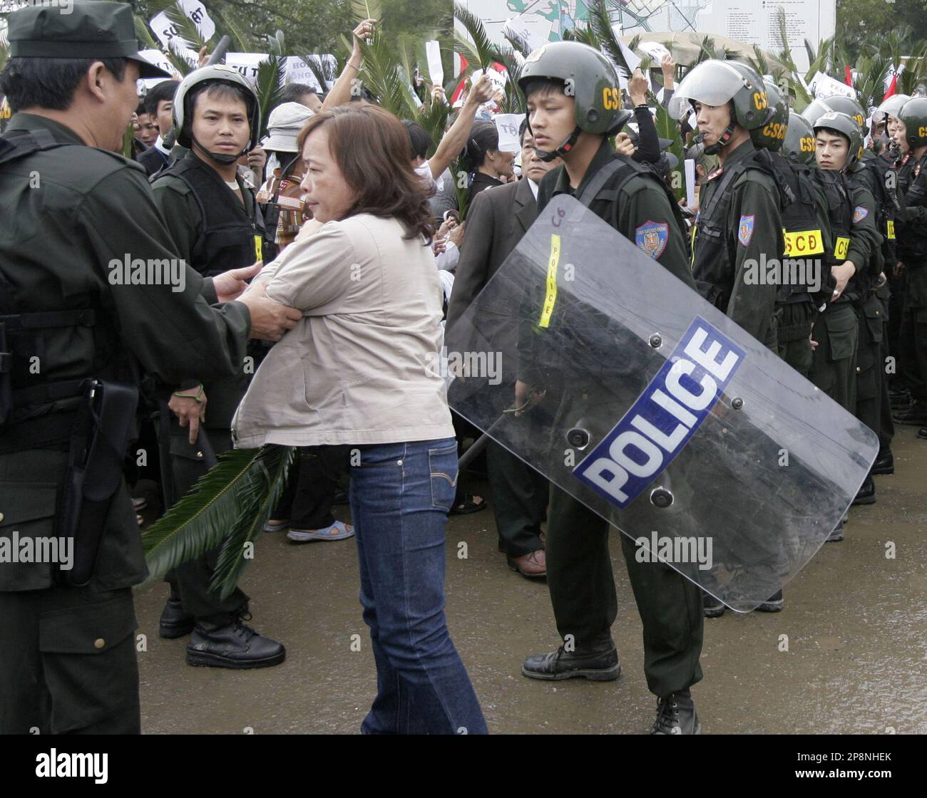 Vietnamese riot police prevent a Catholic woman from accessing the main ...