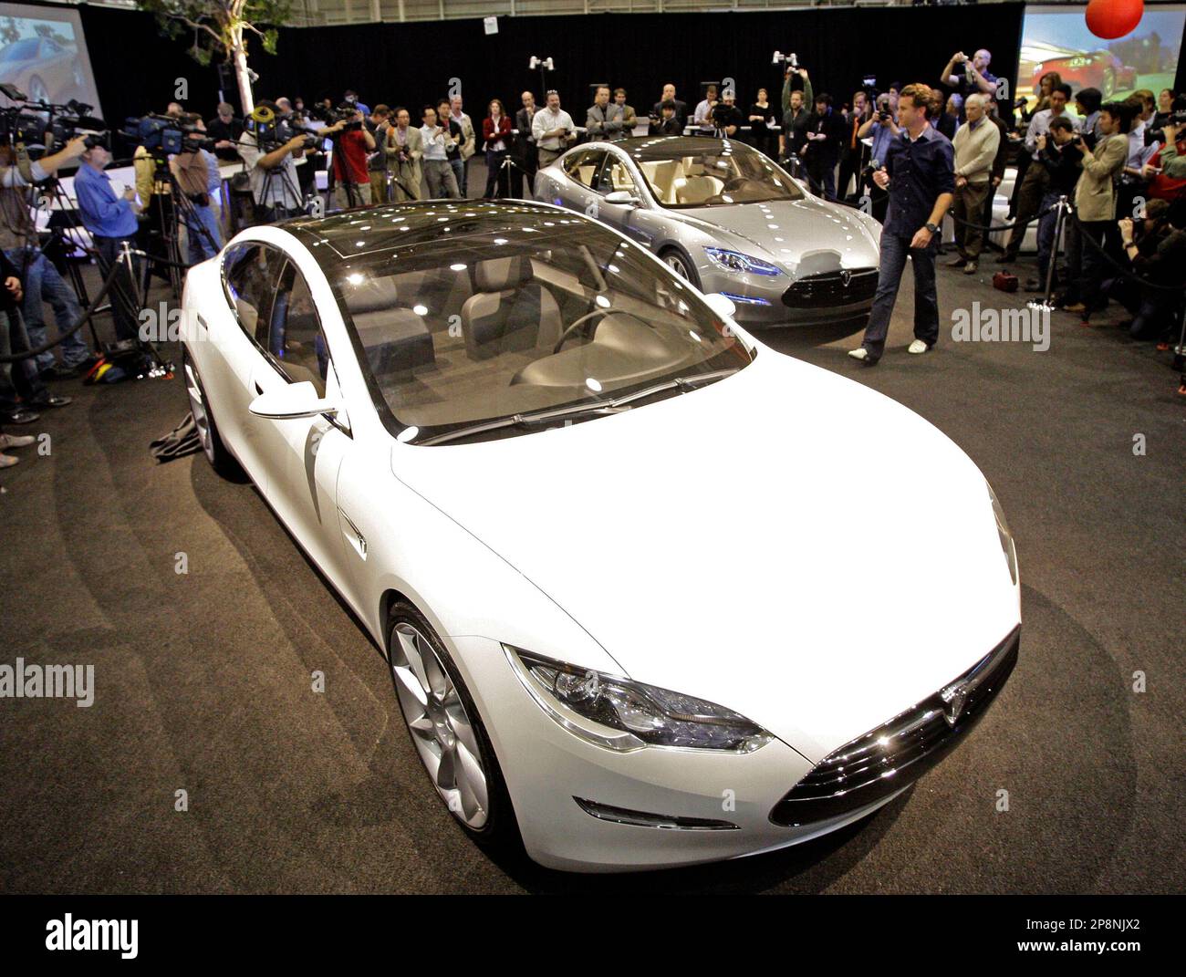 Chief Designer Franz von Holzhausen, right rear, walks between two ...
